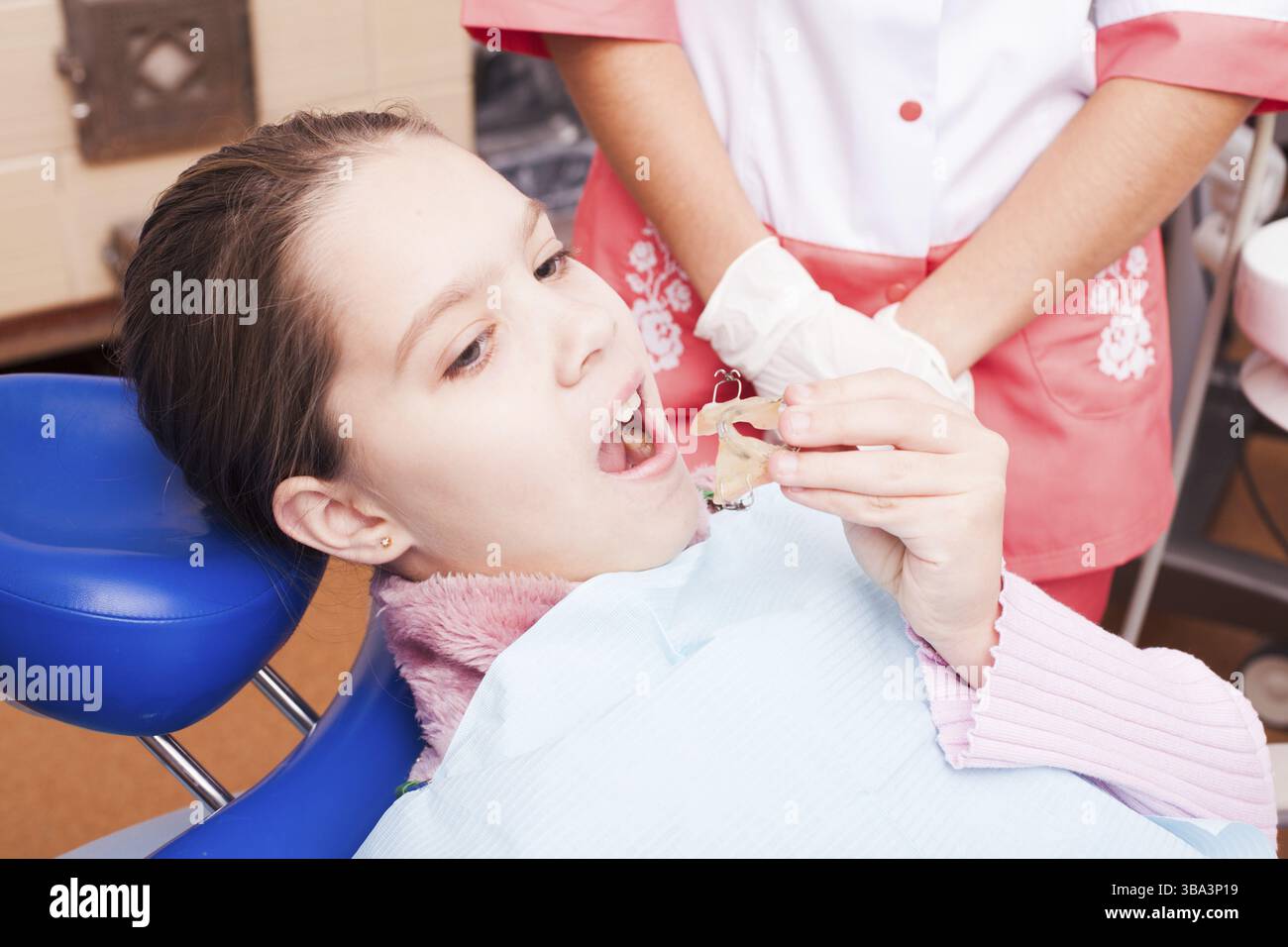 A girl tries to establish a retainer for Teeth Dental Braces, sitting ...