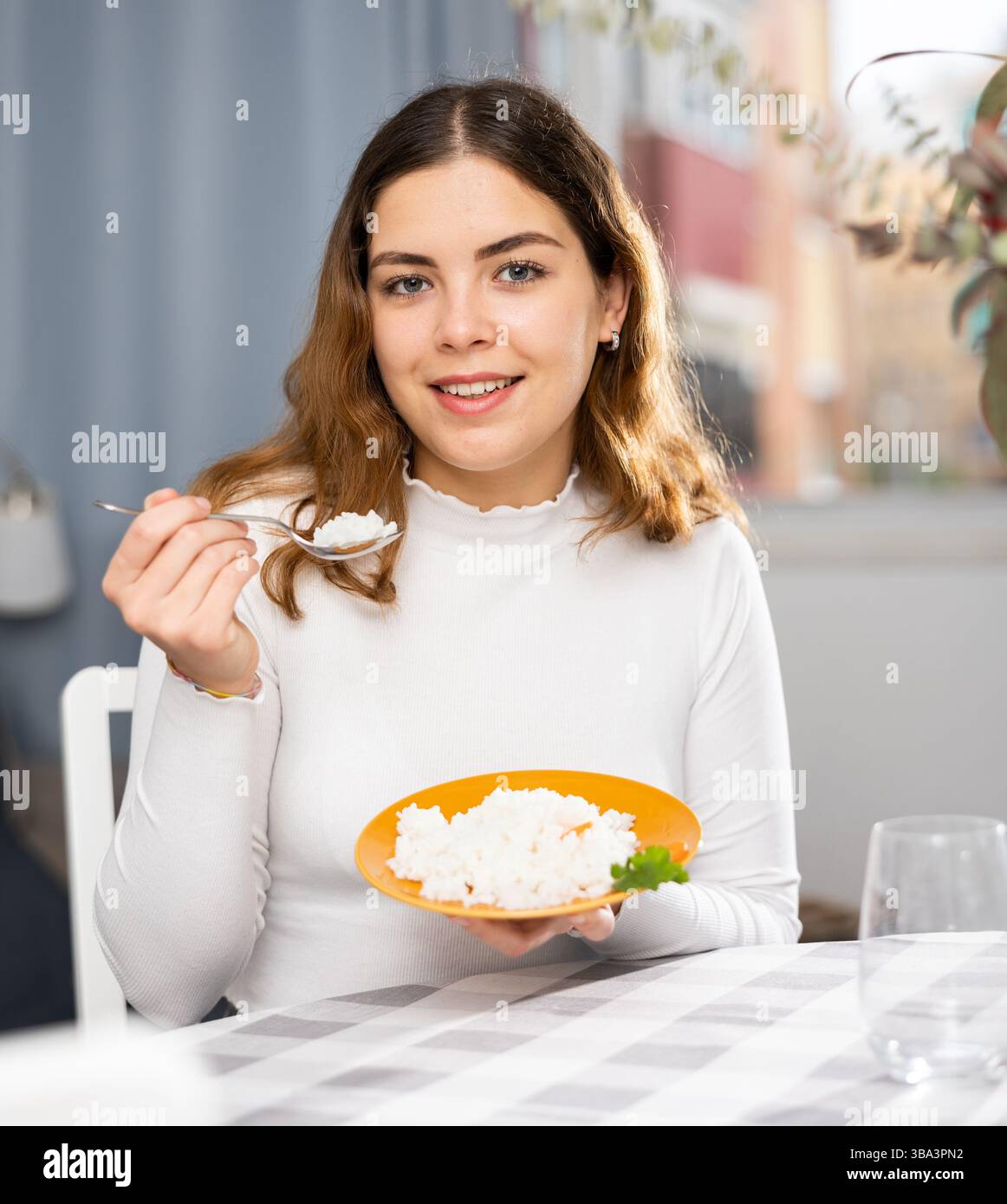 Emotional young woman eating rice at home Stock Photo - Alamy