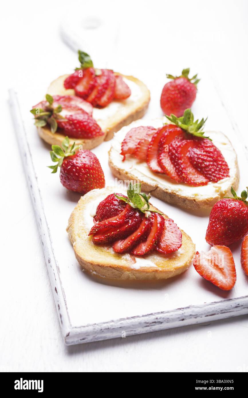 Summer breakfast - toasts with butter and strawberry Stock Photo - Alamy