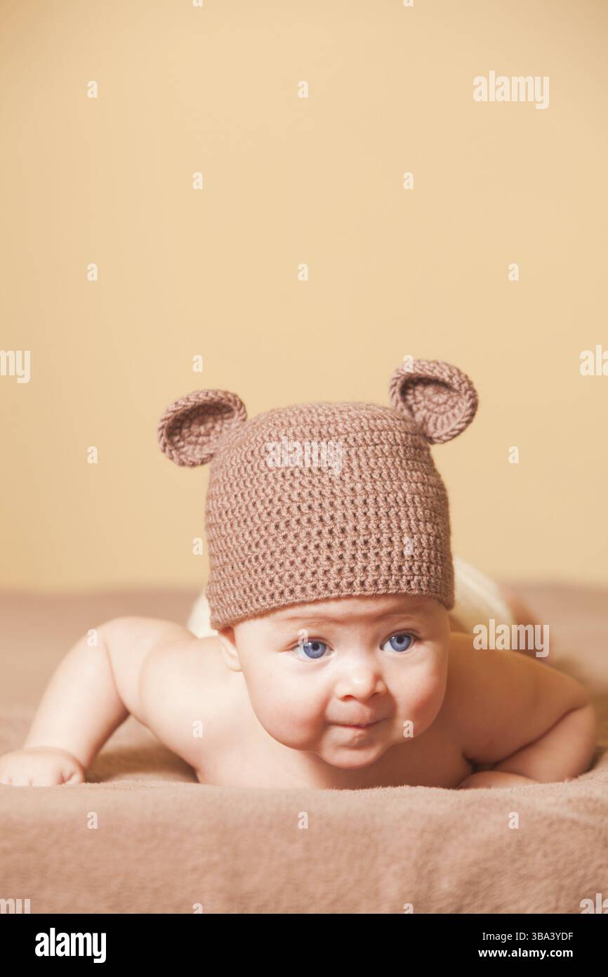 Adorable baby in bear hat lying on the bed Stock Photo - Alamy