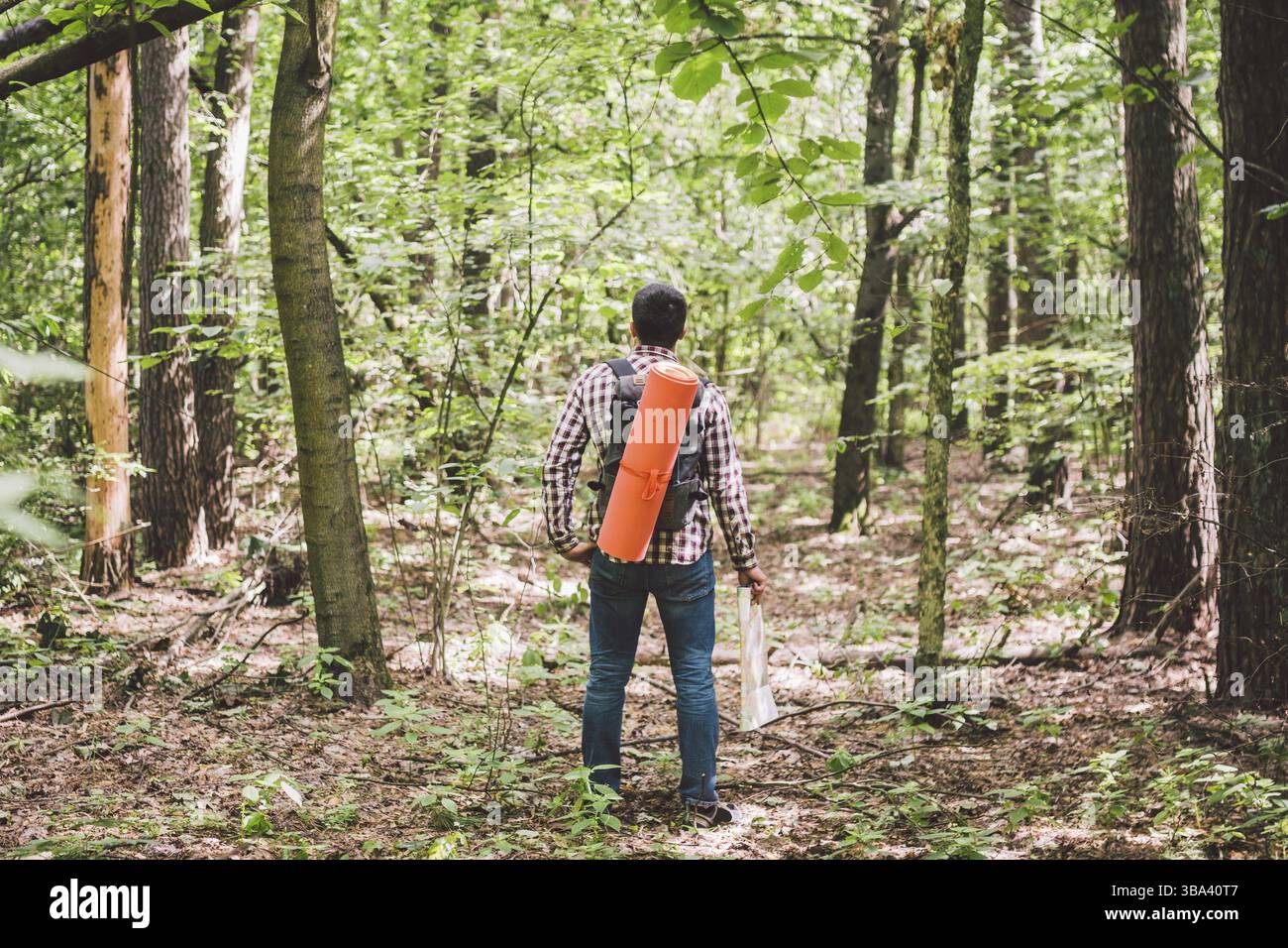 Man with Backpack and map searching directions in wilderness area ...
