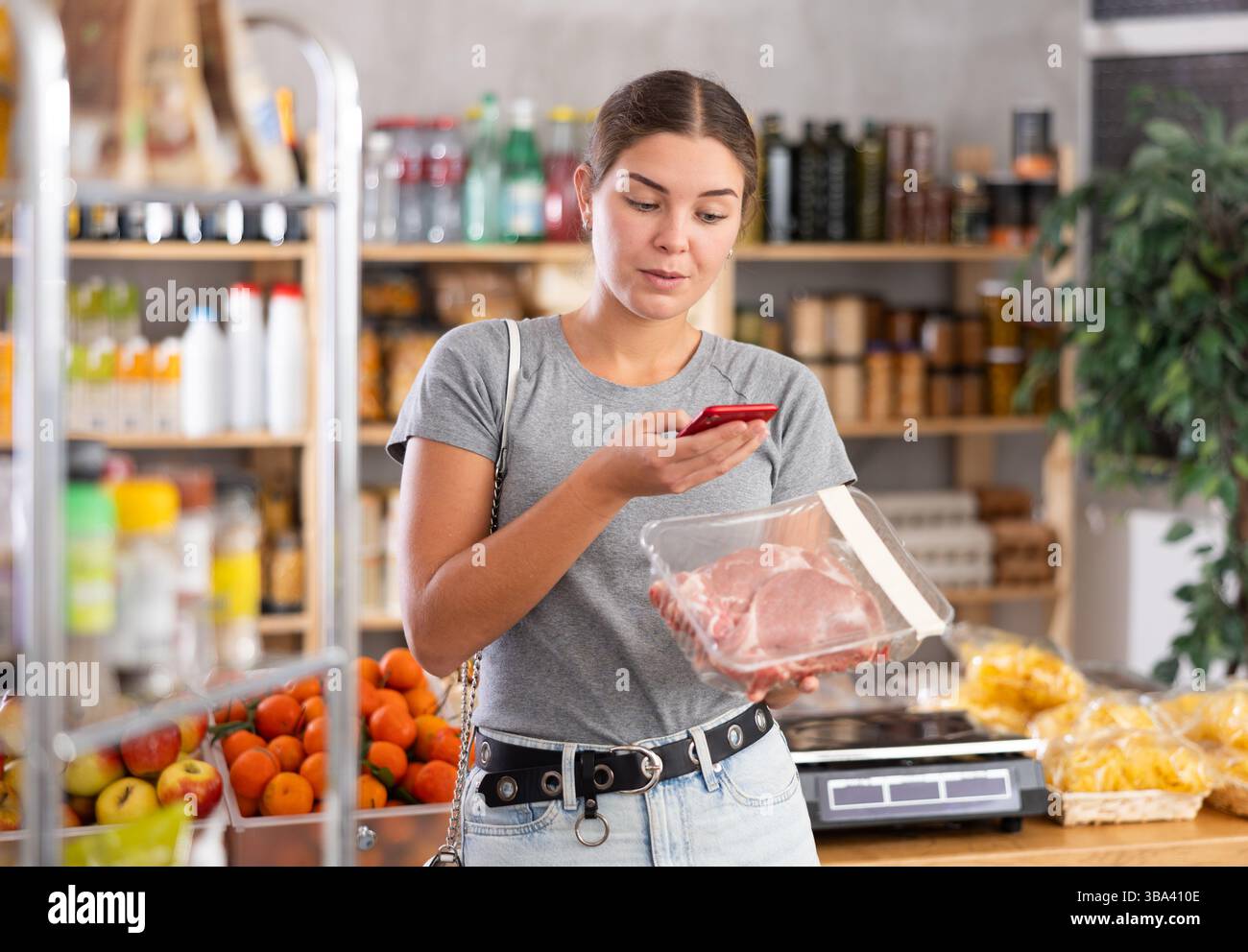 Young woman scanning qr code of raw pork Stock Photo - Alamy