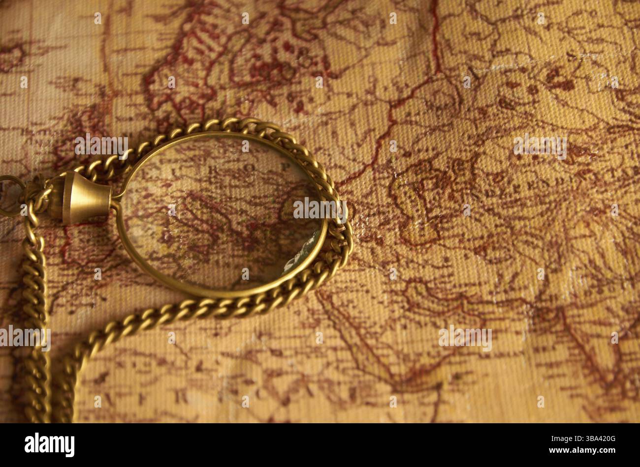 Old gold magnifying glass lying on a map Stock Photo - Alamy