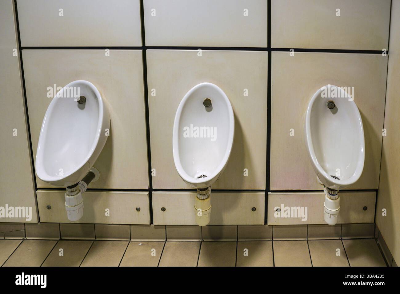 White porcelain urinals in men restroom toilet Stock Photo - Alamy