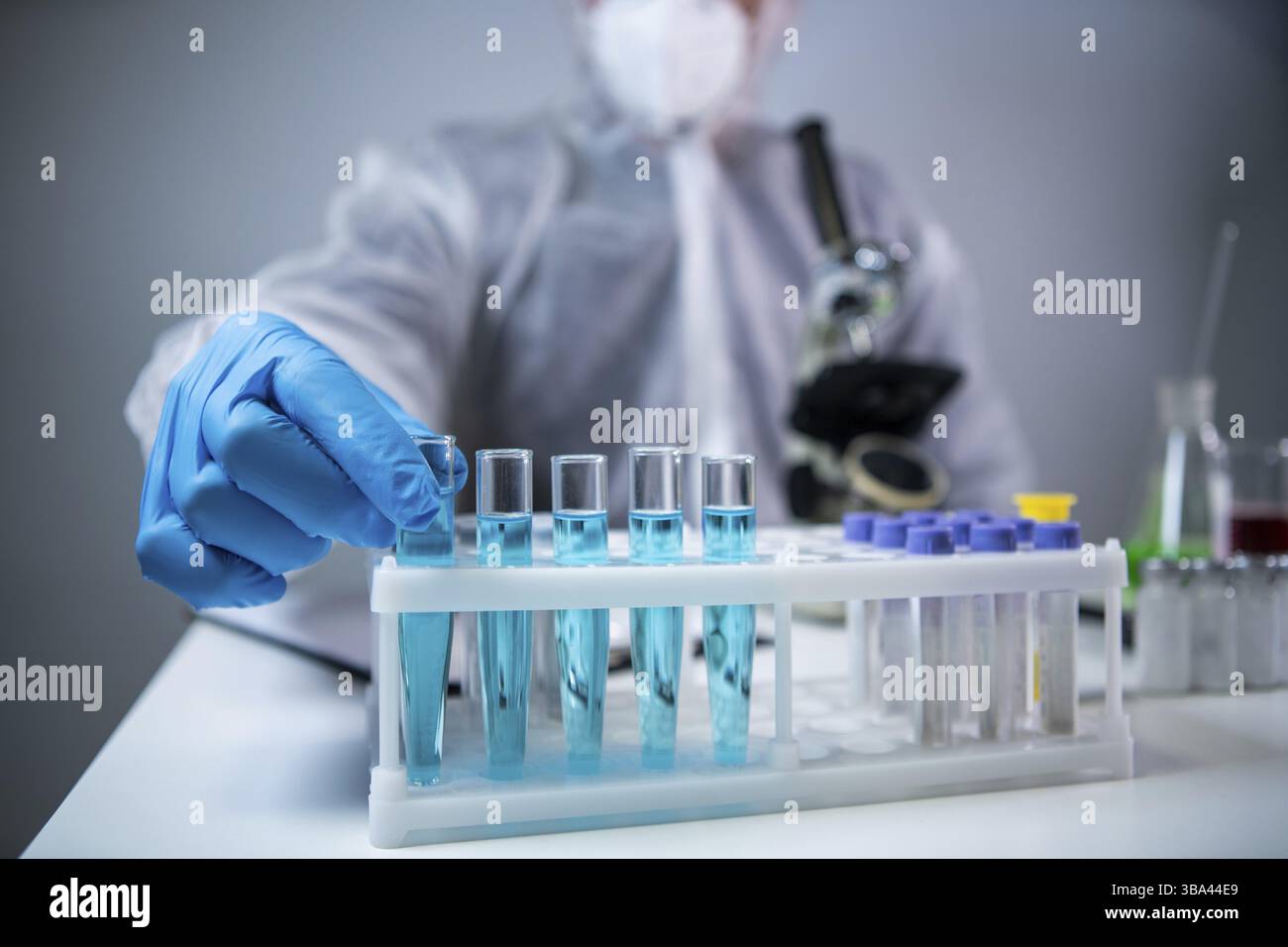 Biochemistry laboratory research, chemist in protective suit analyzing ...