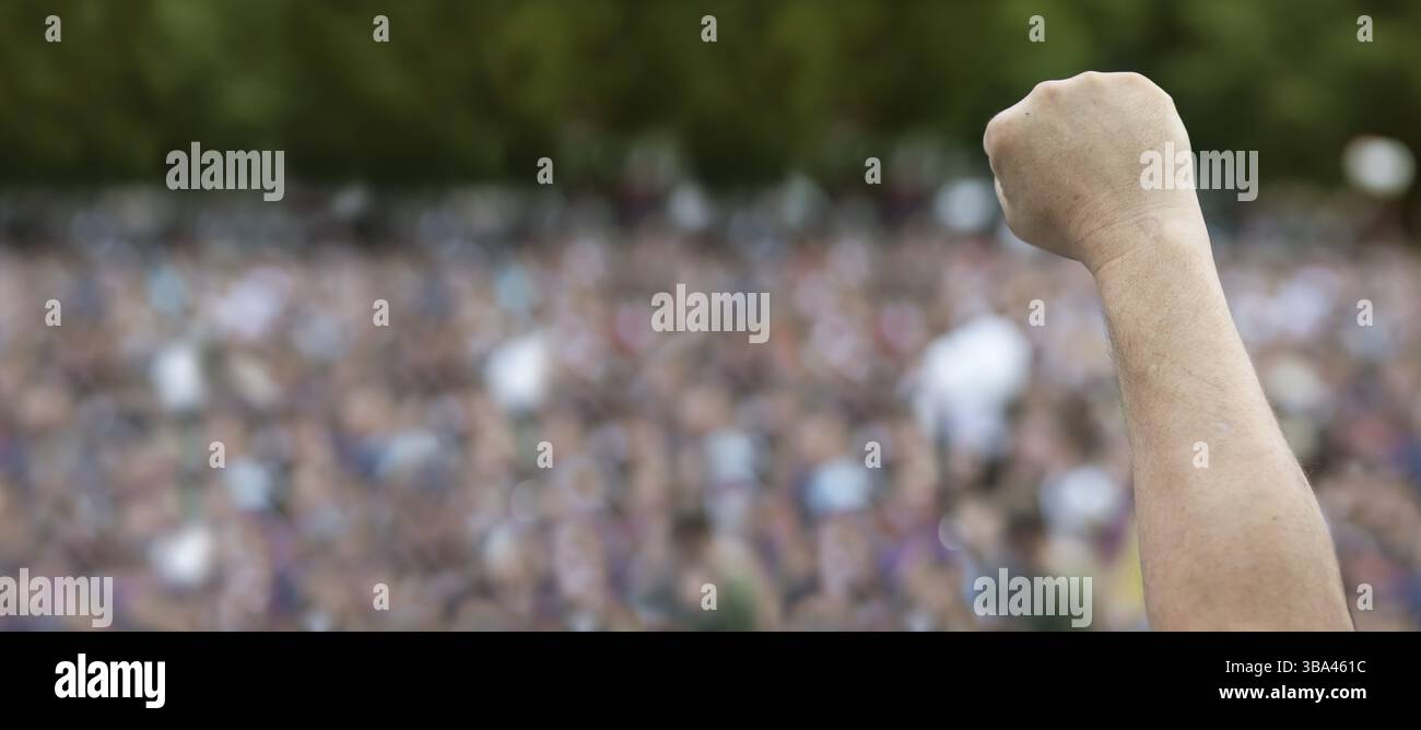 A hand in a fist in protest against a blurred crowd of people Stock ...