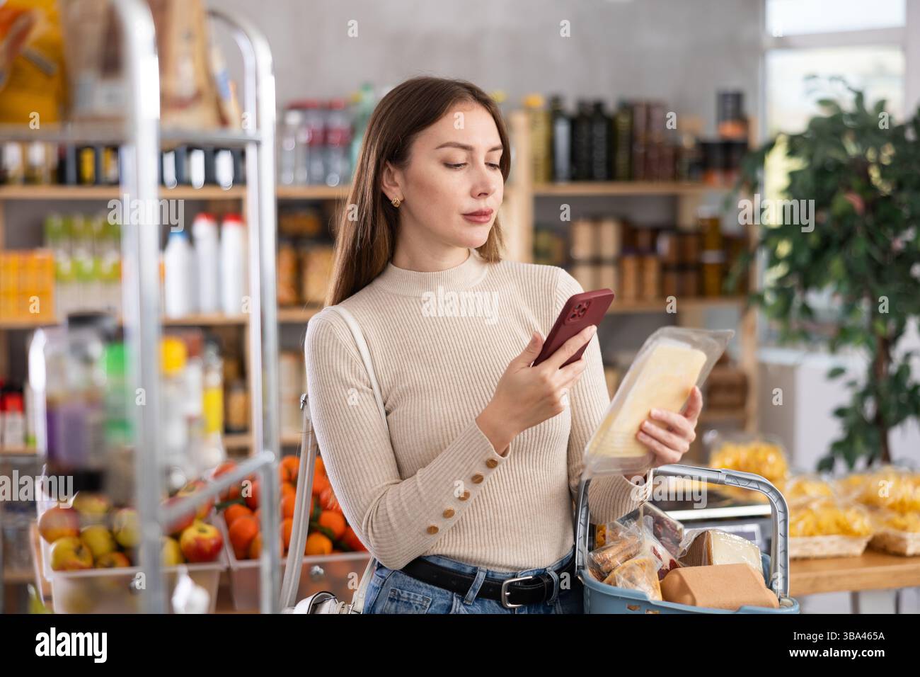 Girl scan QR-code on cheese in store Stock Photo - Alamy