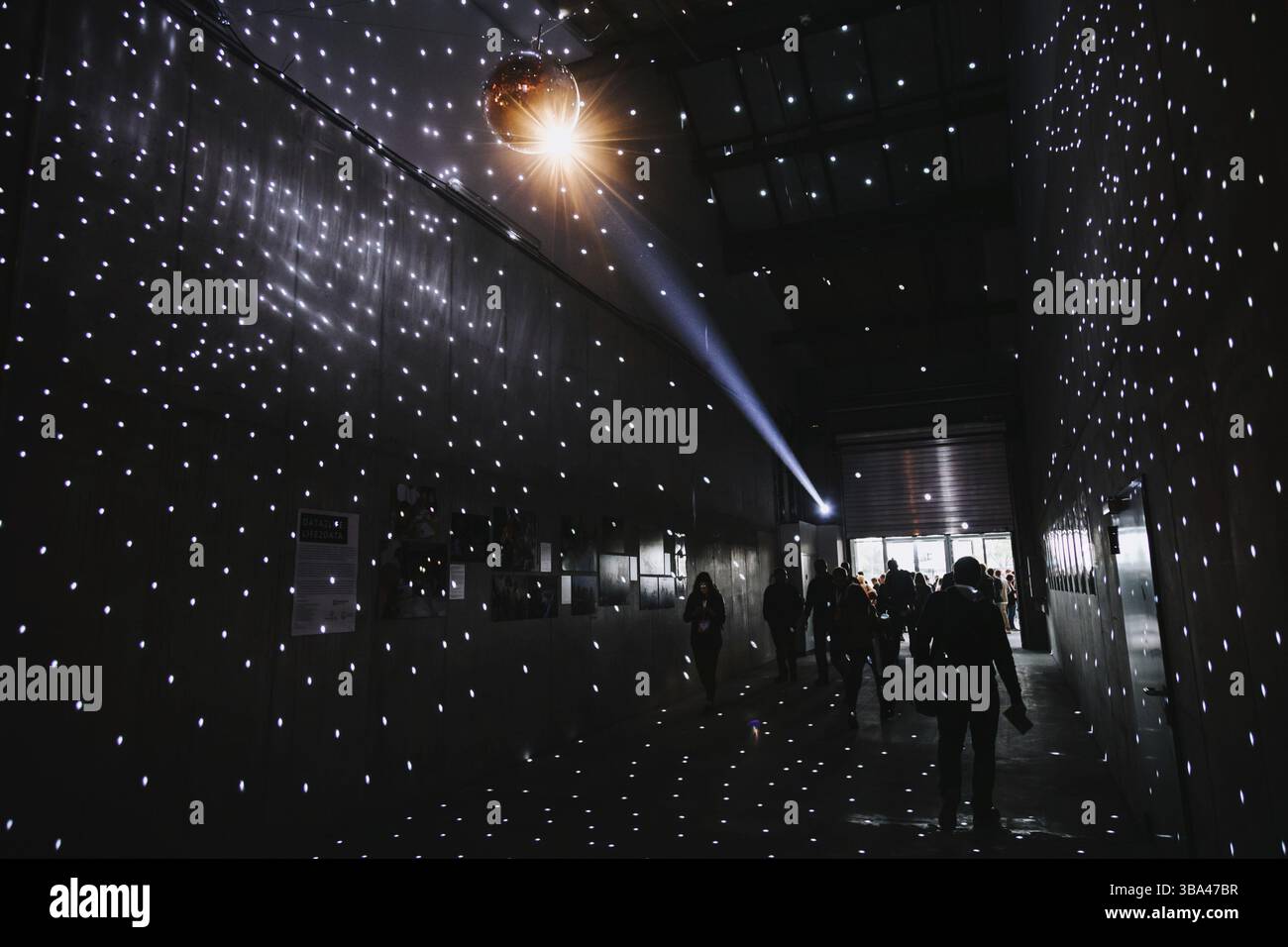 Art installation with flickering lights and visitor people walking in ...