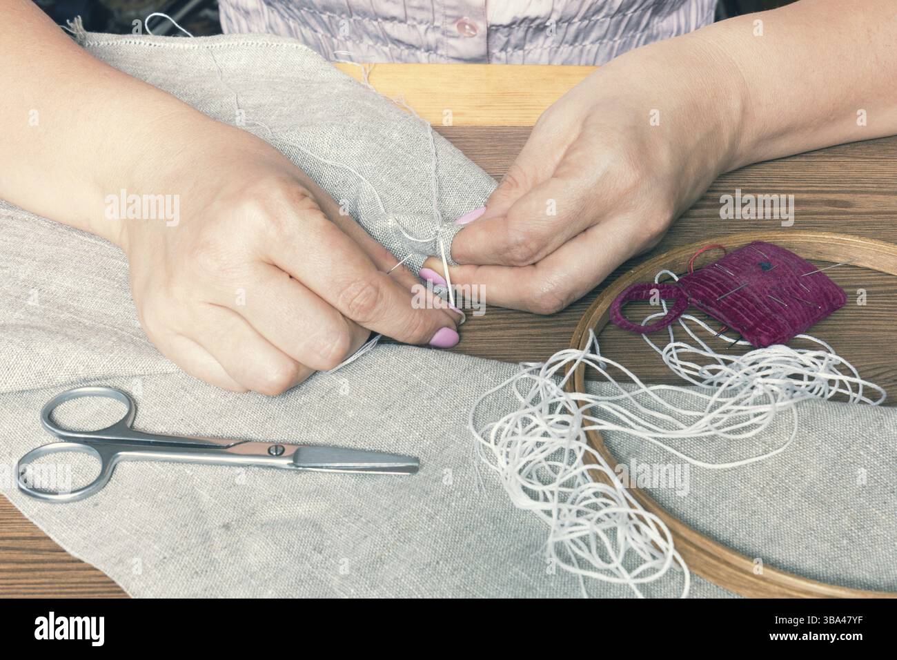 Woman hands doing openwork embroidery on homespun linen. Close up ...