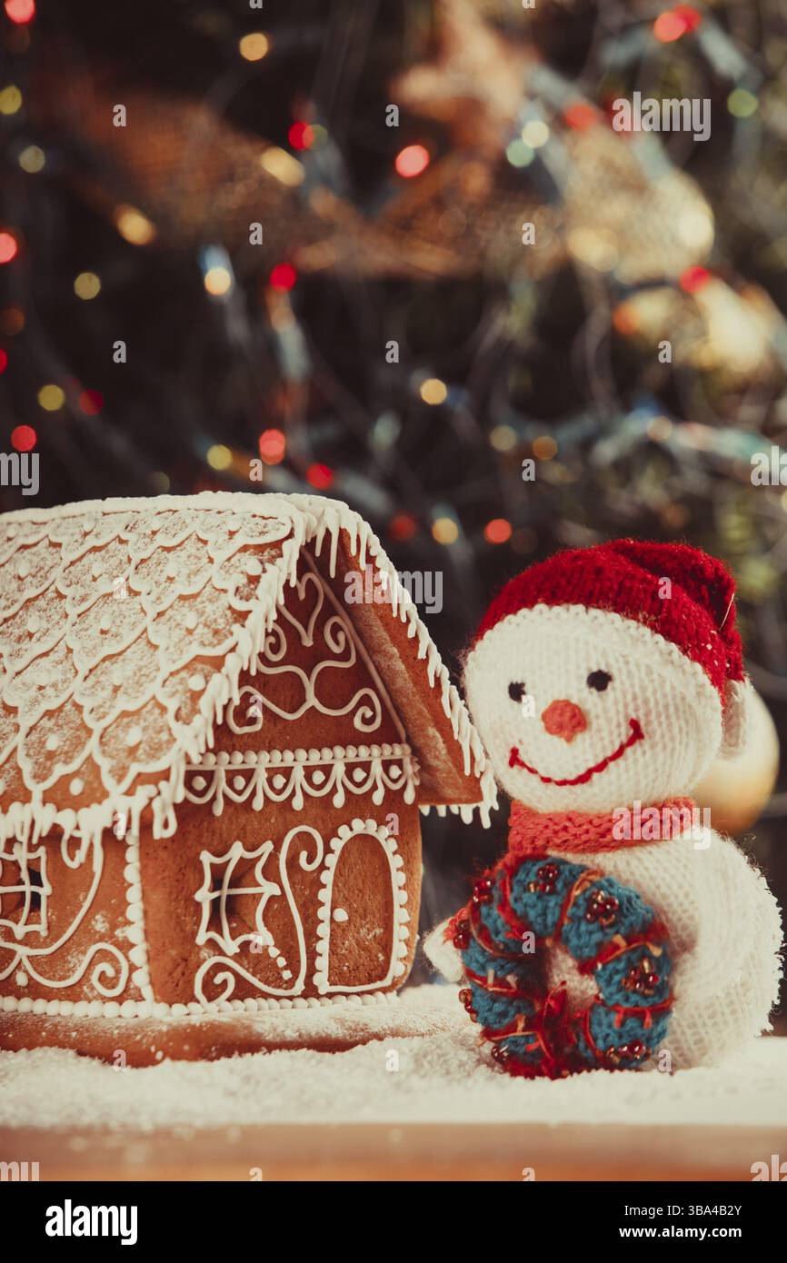 Gingerbread house on the snow, snowman and candlestick Stock Photo - Alamy