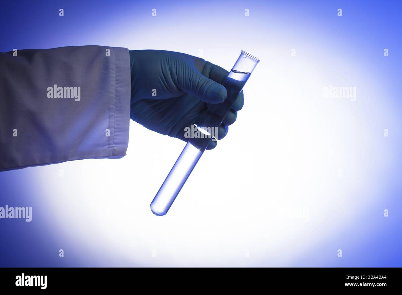 Hand in rubber glove holding a test tube with transparent liquid on ...