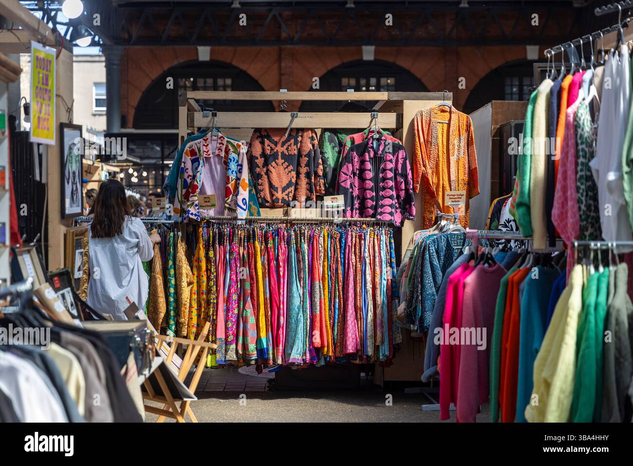 London, UK, 10 May 2025, A vibrant display of colorful clothing hangs ...