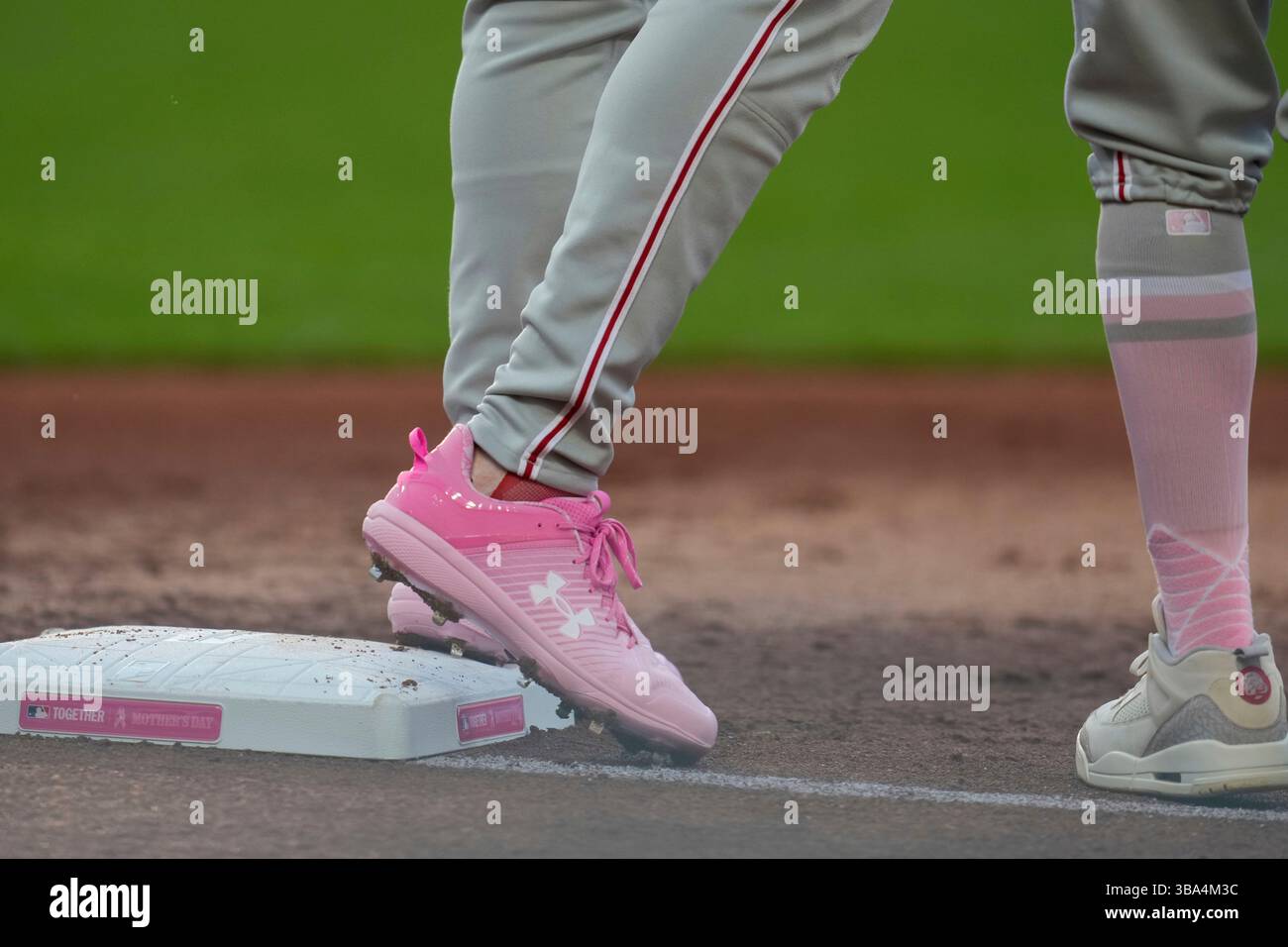 Philadelphia Phillies third baseman Alec Bohm, left, wears pink cleats ...