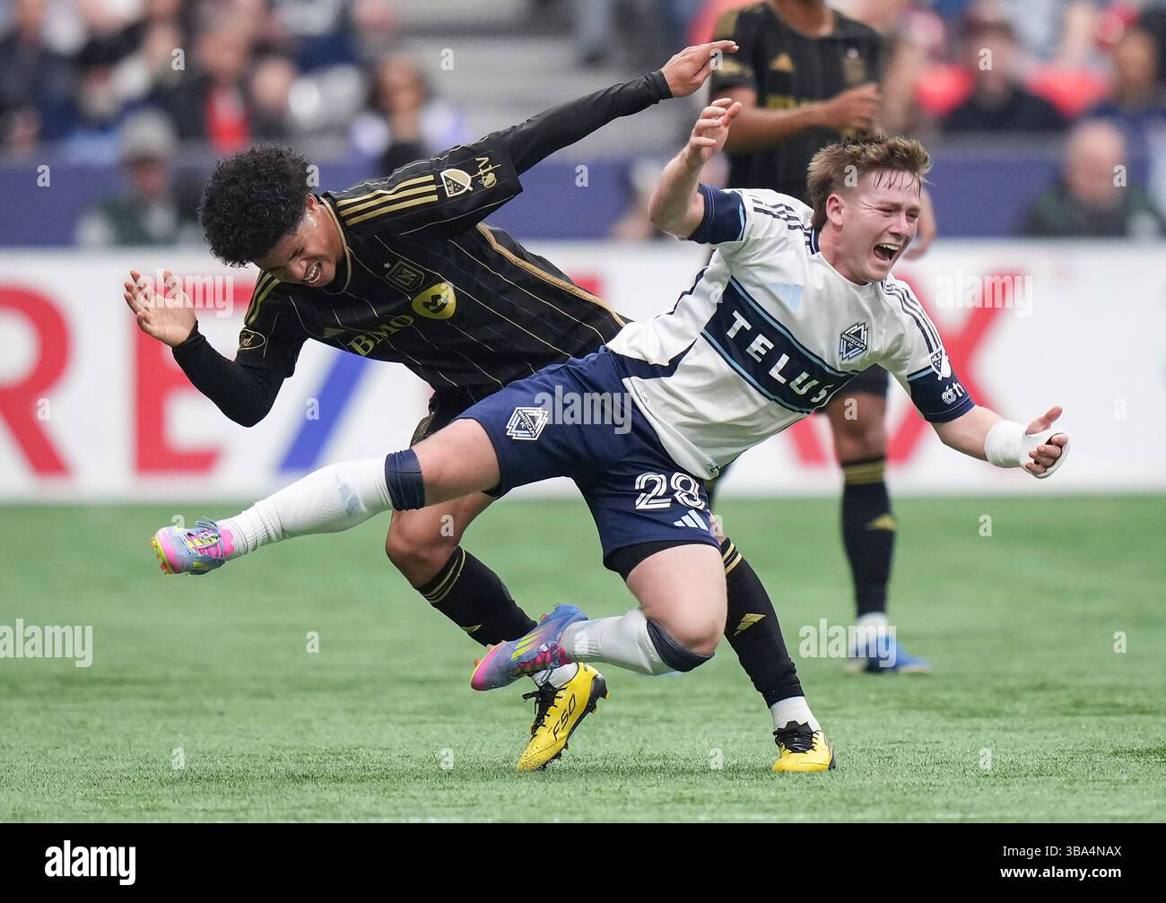 Vancouver Whitecaps' Tate Johnson (28) is upended by Los Angeles FC's ...