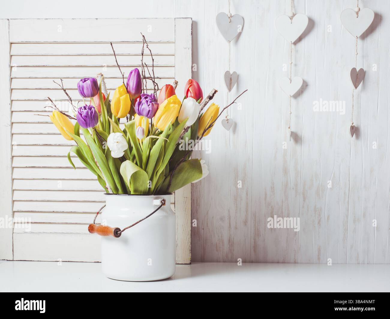 Color tulips with branches in a white cane. Spring decor Stock Photo ...