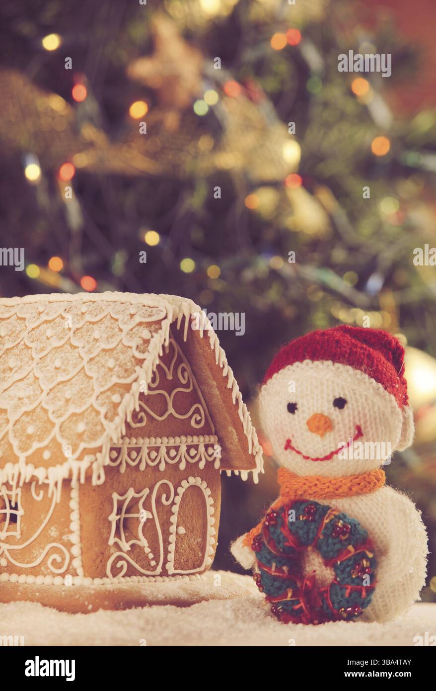 Gingerbread house on the snow, snowman and candlestick Stock Photo - Alamy