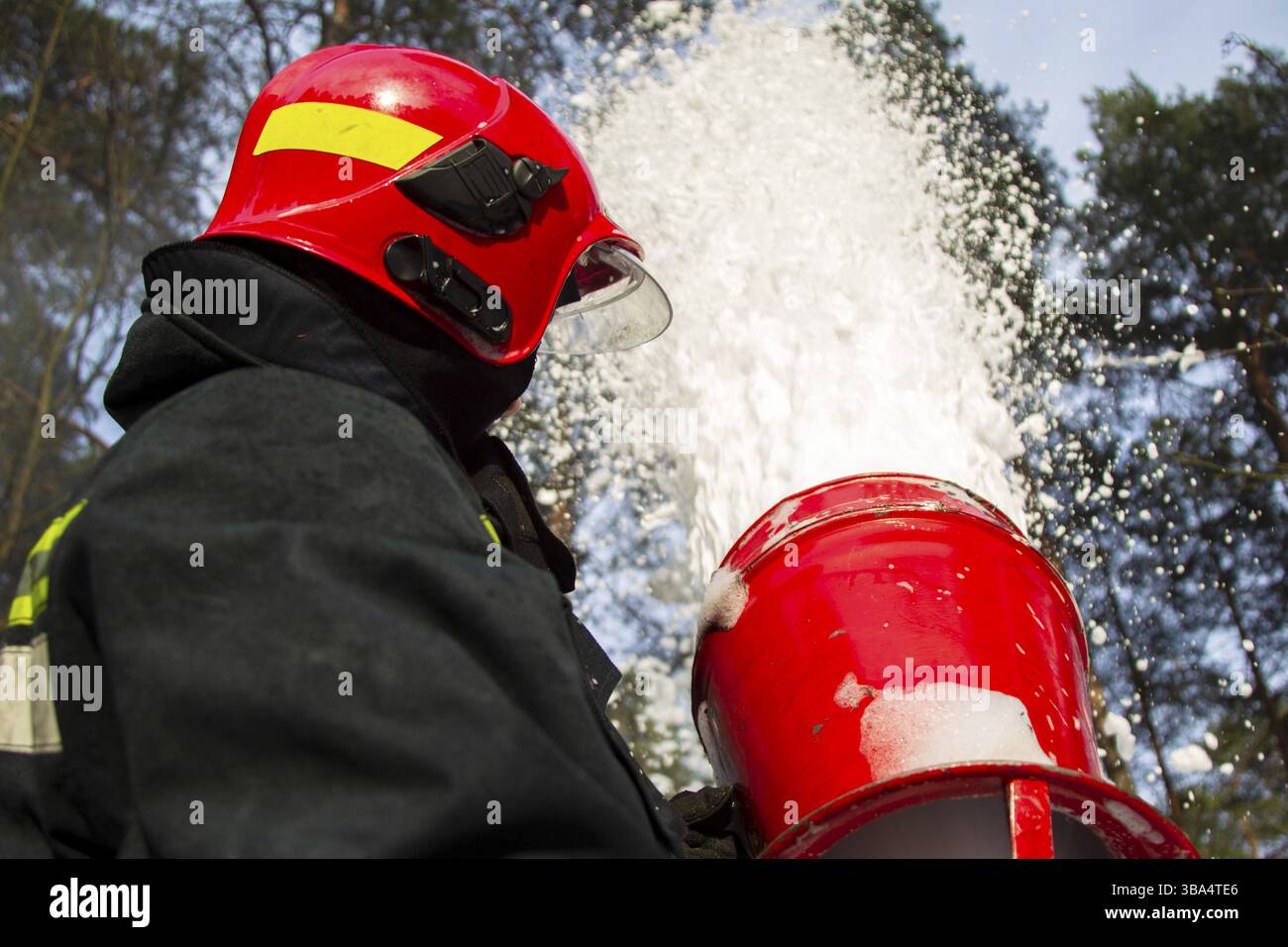Firefighter puts out a forest fire. Fireman with hoses with foam on the ...