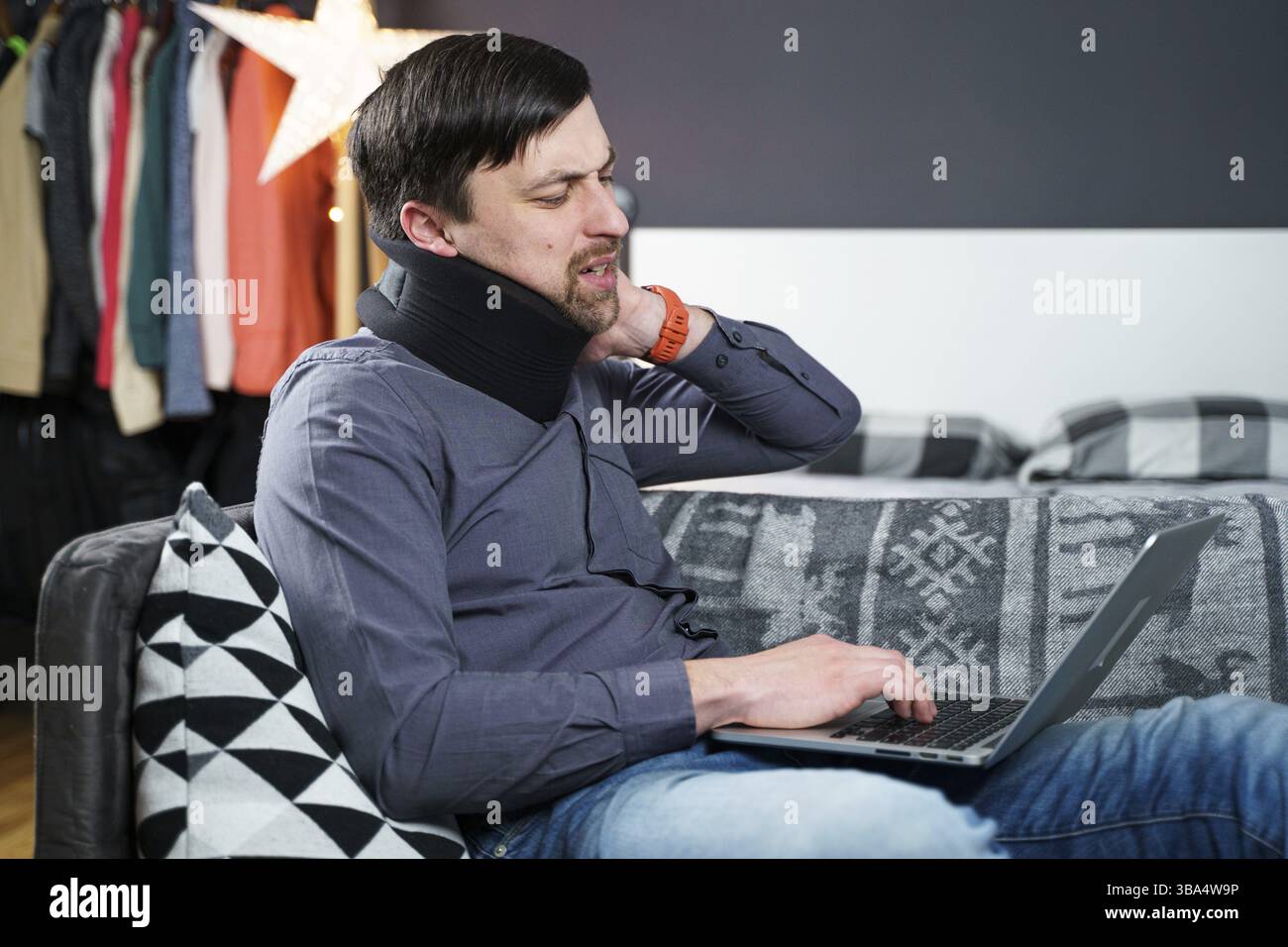 Tired strained man suffering from neck pain while working at computer ...