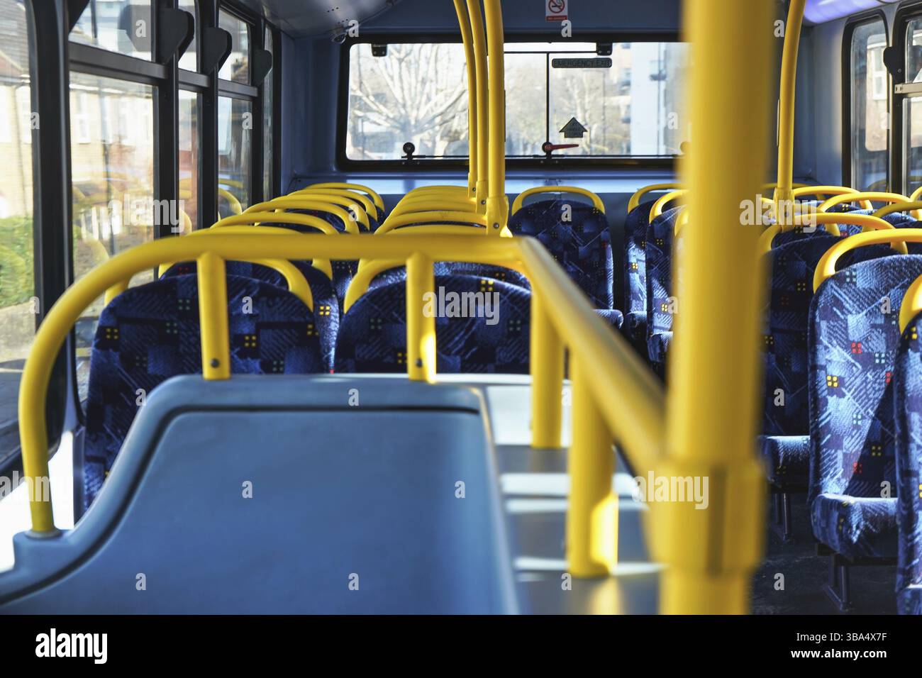 Sun shines on empty interior of London double decker bus, yellow ...