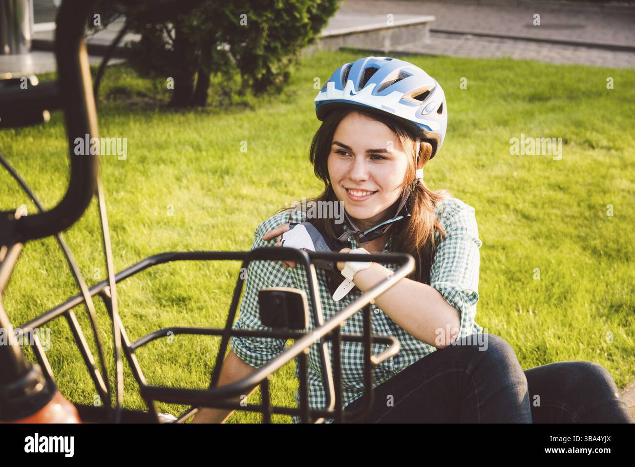 Female cyclist in professional cycling clothing and helmet sitting near ...