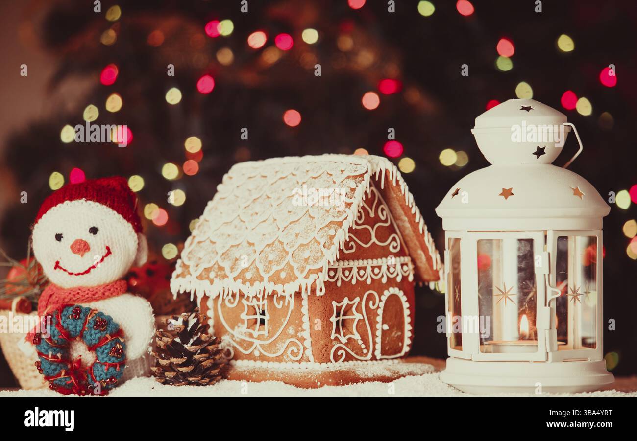 Gingerbread house on the snow, snowman and candlestick Stock Photo - Alamy