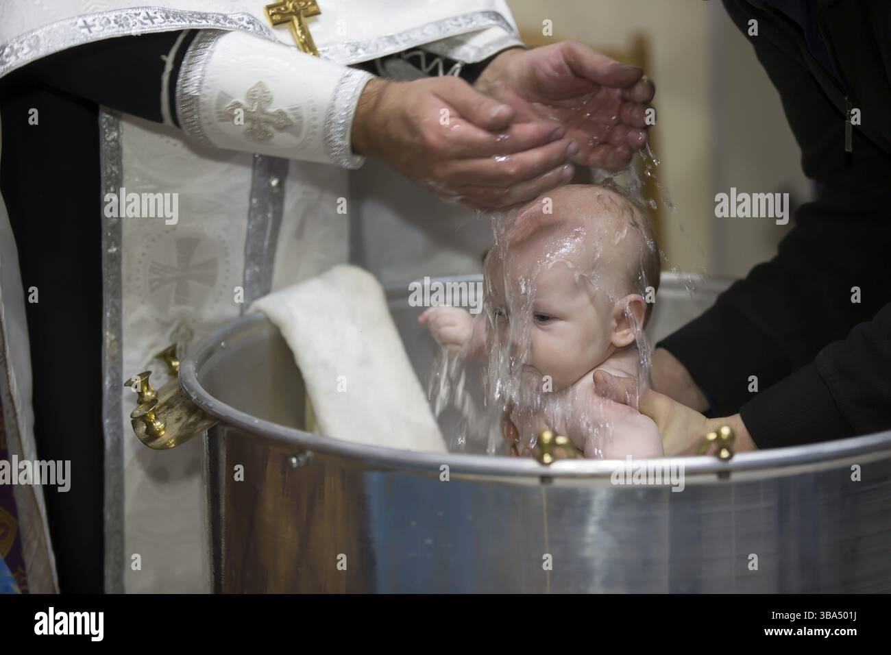 Priest pours water on the infant at baptism. Orthodox rite of baptism ...