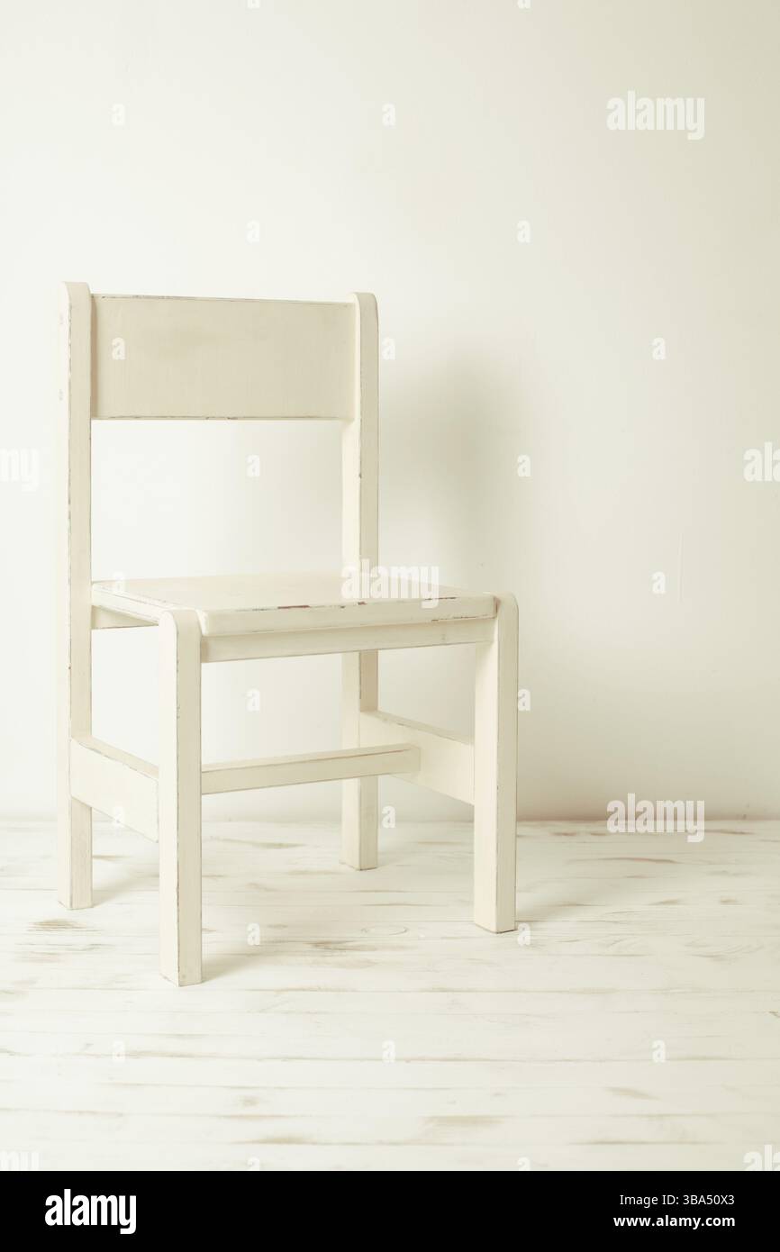 Single white rustic chair standing in an empty room on light wooden ...