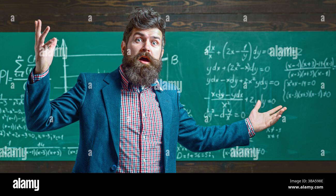 Teacher explains math at blackboard. Teacher in classroom with ...