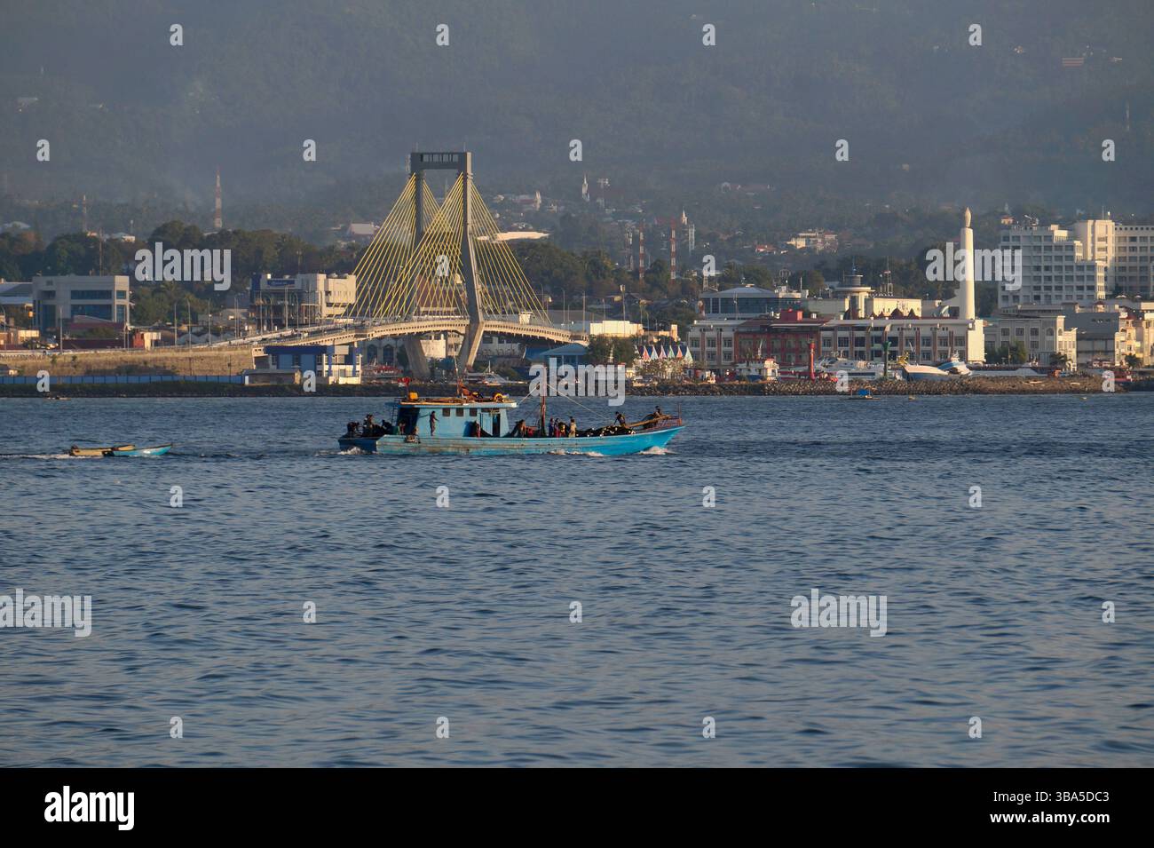 Fishing boats pass around the Soekarno bridge in the coastal area of ...