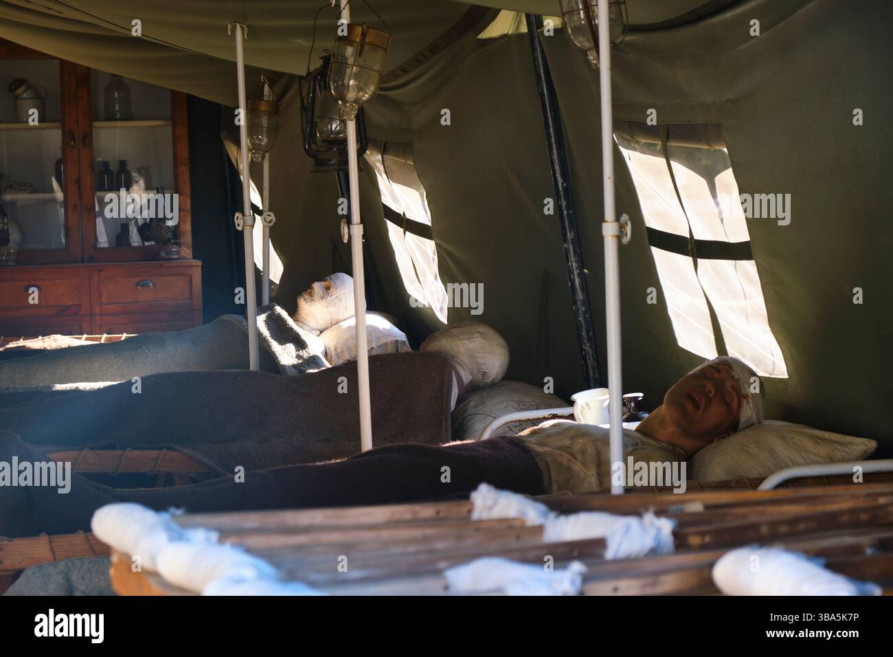 Patients inside a large, green, canvas field hospital tent set up out ...