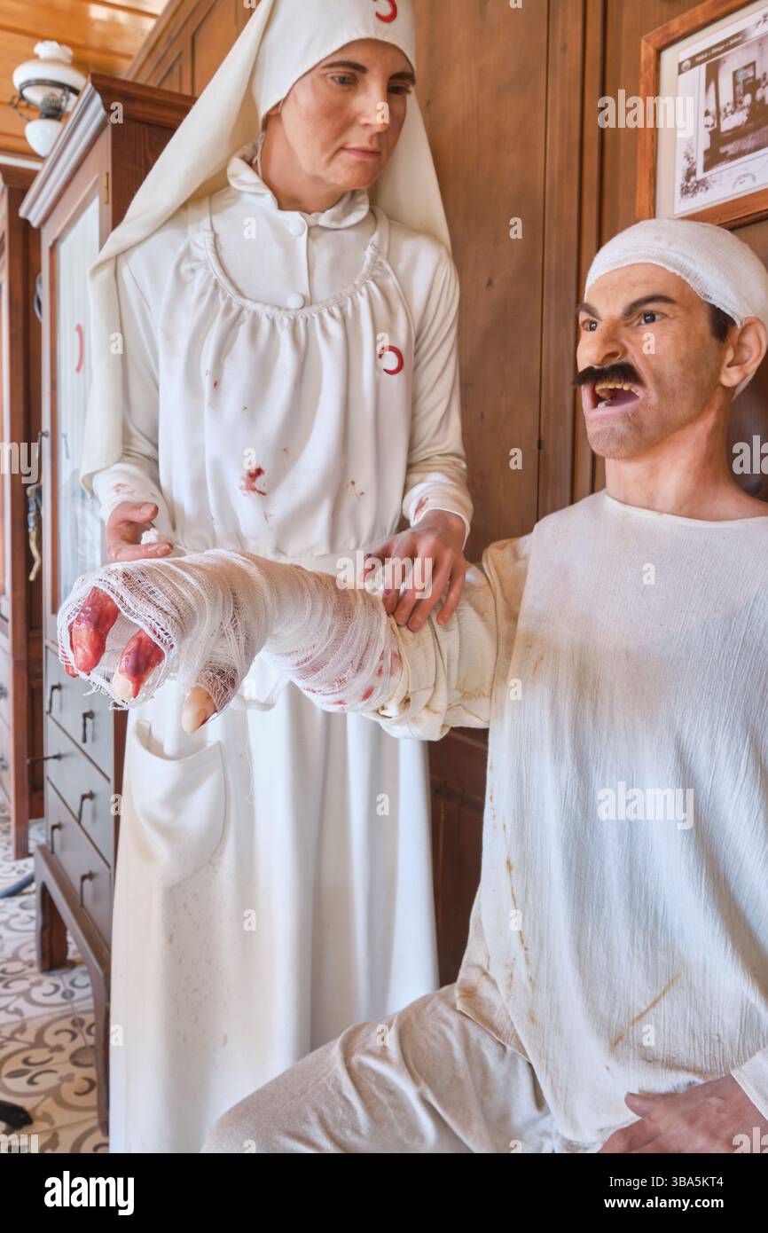 An army nurse wraps the bloody hand of a wounded Turkish soldier. At ...