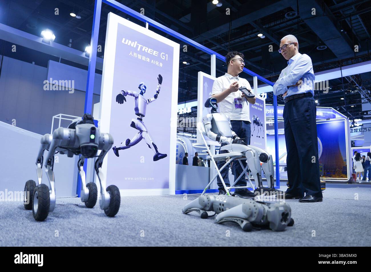 A visitor listens to the exhibitor introducing information about robots ...
