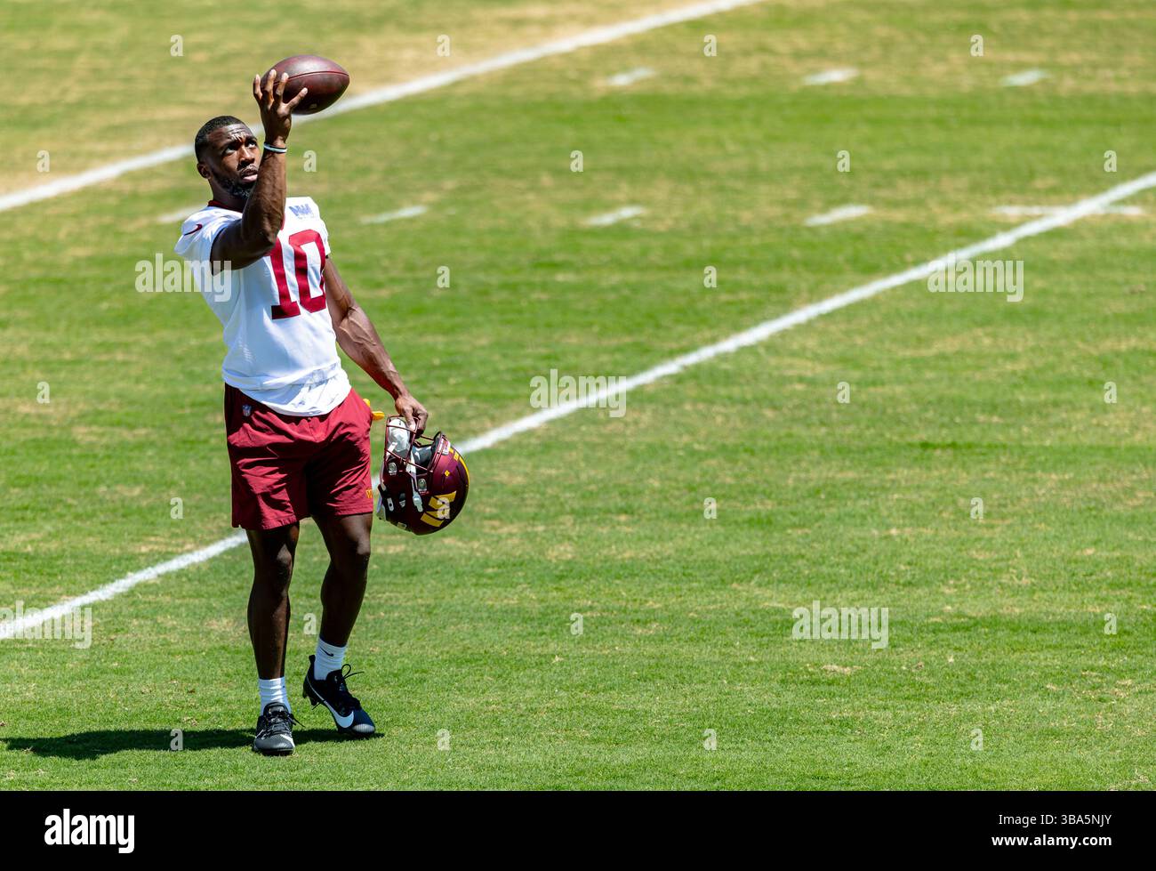 Wide Receiver Jacoby Jones catches a ball one handed from a trainer ...
