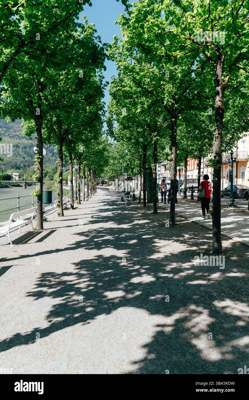 Visitors enjoy a leisurely stroll along the shaded promenade in Bad ...