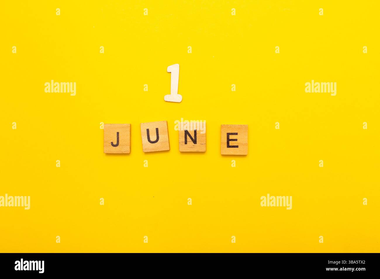 Top view of word 1st June calendar date made by wooden cubes on yellow ...