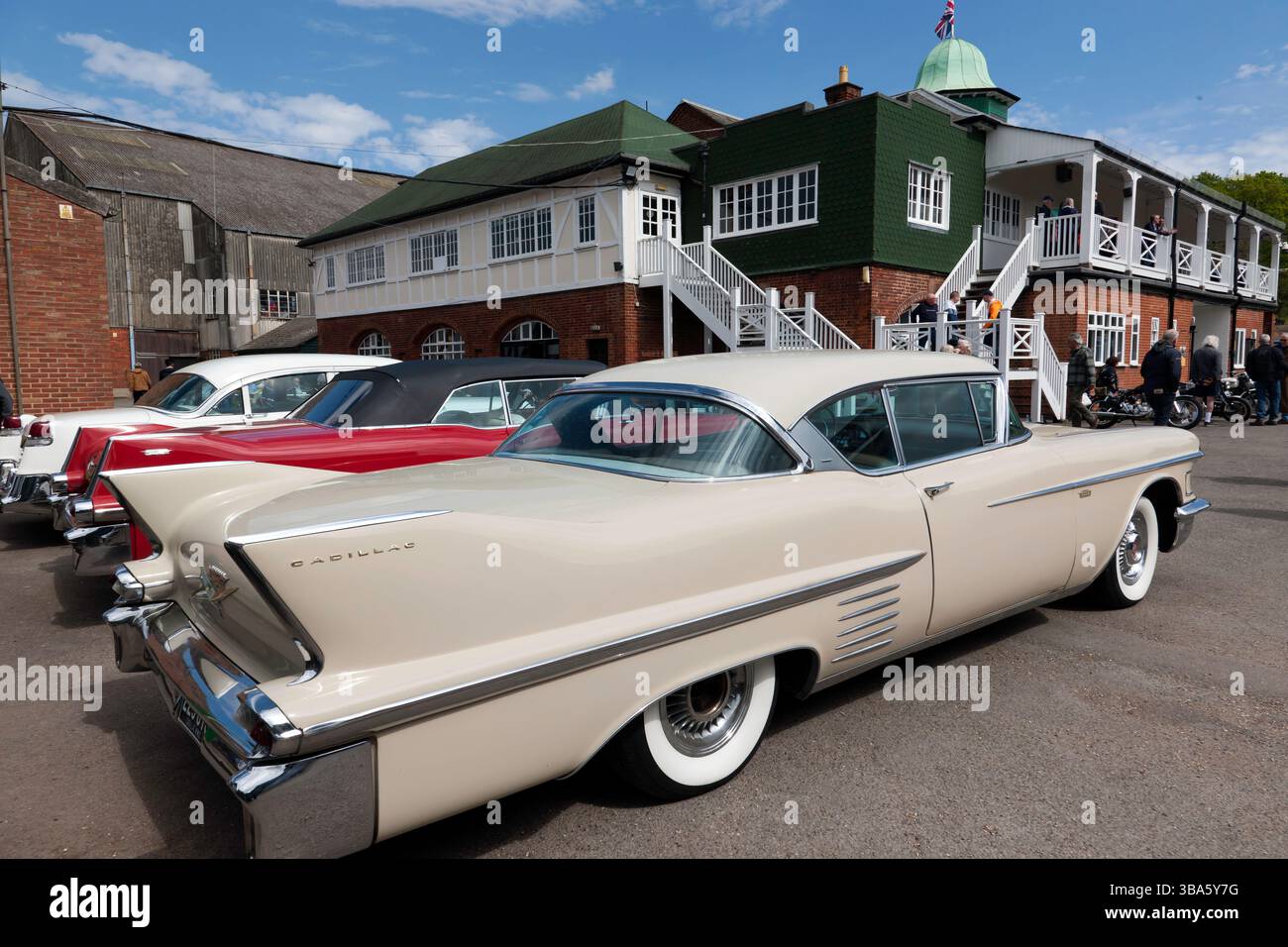 Three-quarters rear view of a Cream, 1958, Cadillac Deville, on display ...