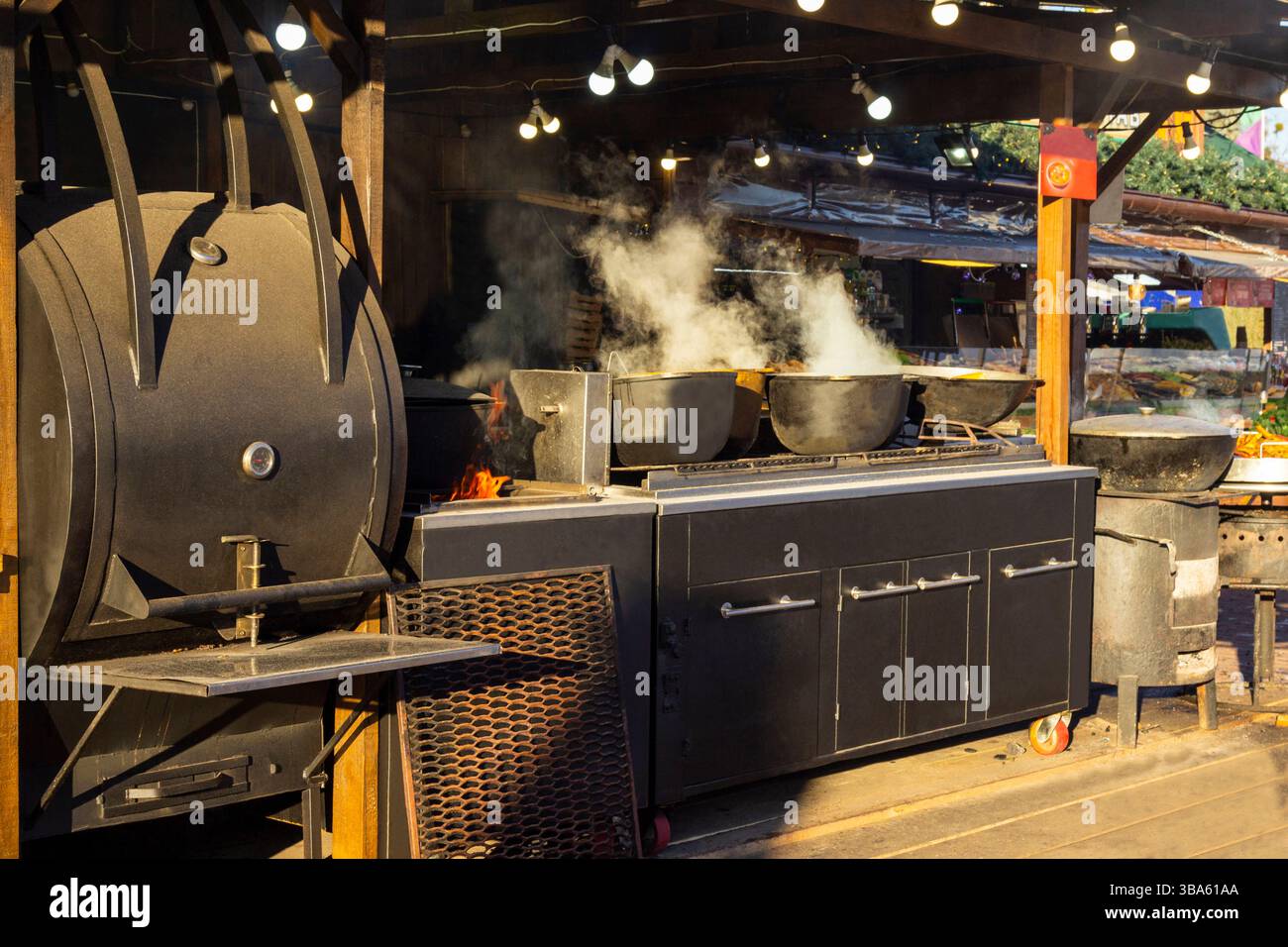 Two large pots on the stove in an outdoor kitchen. Steam comes out of ...