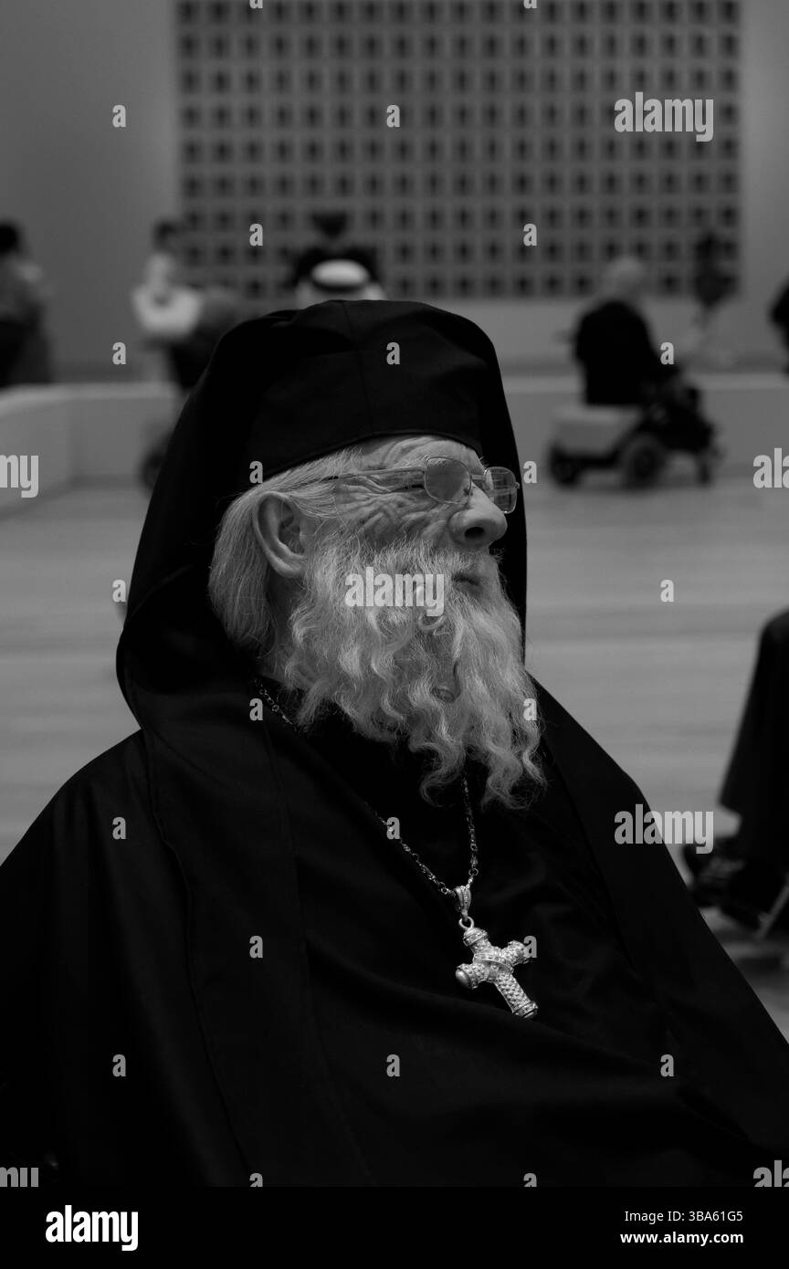 An elderly figure dressed in religious attire with a large cross ...