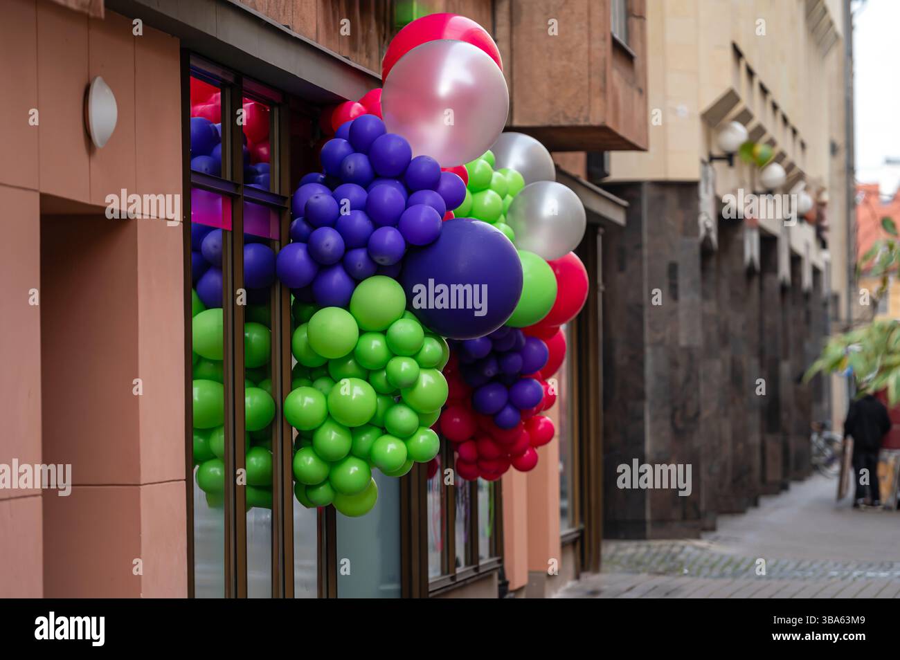 Colorful balloons in various sizes and shapes fill the storefront ...