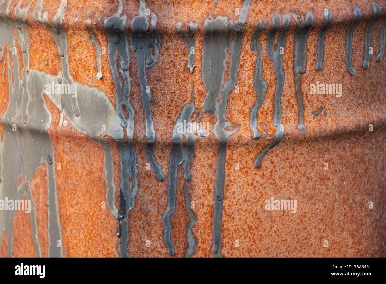 Rusty barrel with black paint drips as background close-up, rusty ...