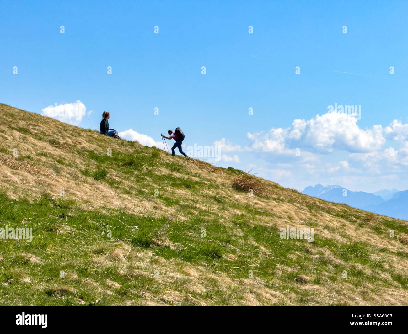 Hiker walking up to Edelsberg peak with Sportheim Böck mountain hut in ...
