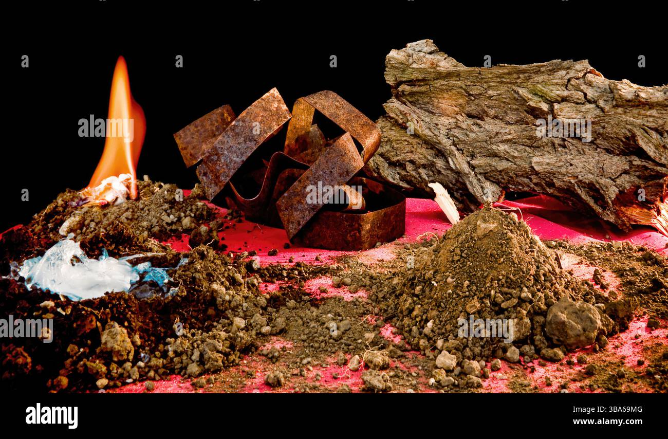 Fire burning next to a piece of ice melting on soil, a rusty metal ...