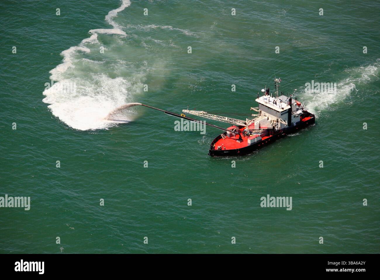 An aerial photo of a ship dredging an inlet Stock Photo - Alamy