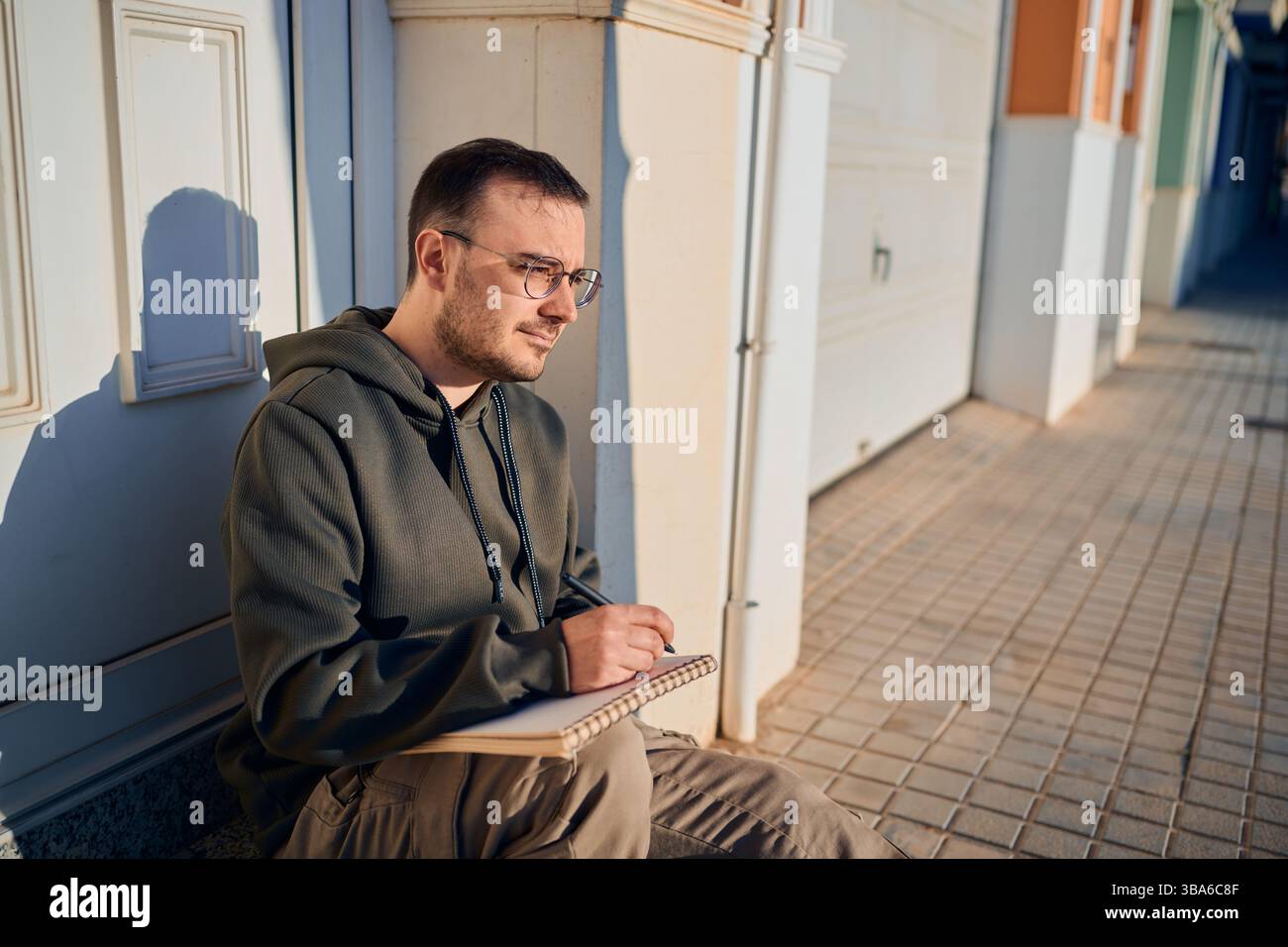 Young creative man drawing outdoors, sketching in urban setting Stock ...