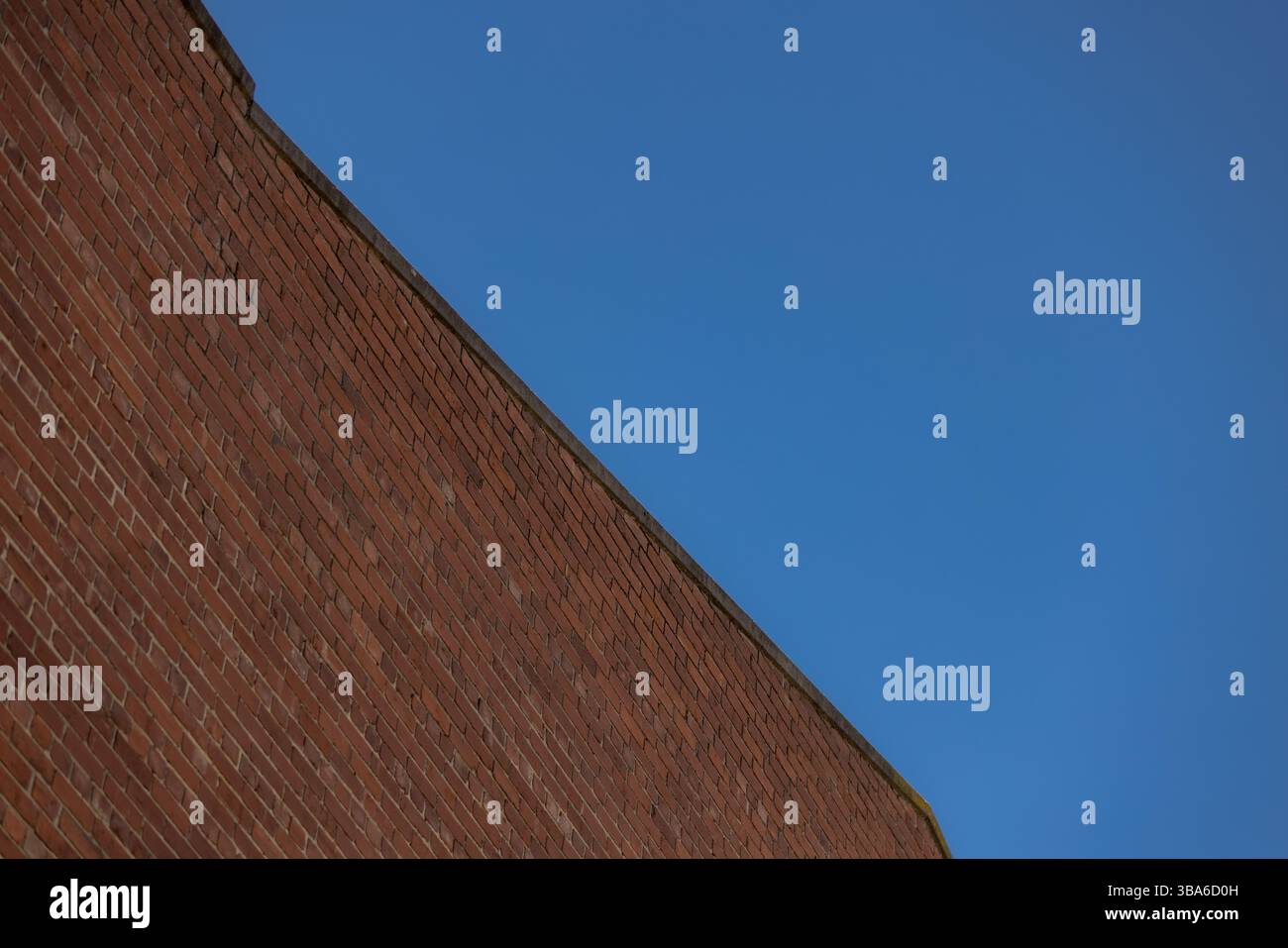 Diagonal red brick wall with blue sky forming geometric pattern Stock ...