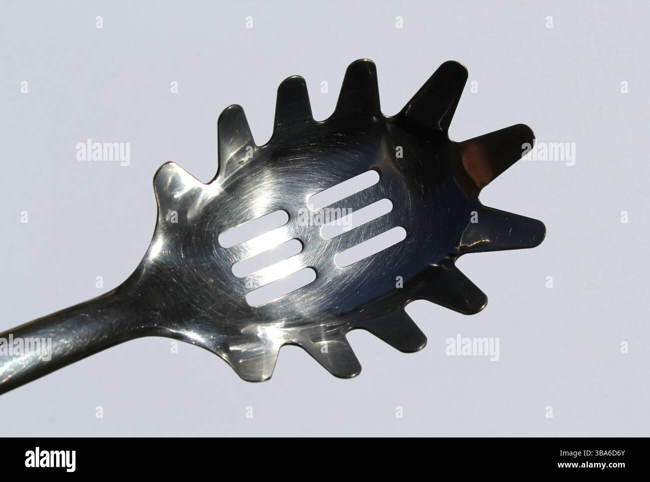 Metal pasta spoon server kitchen utensil against a white background ...
