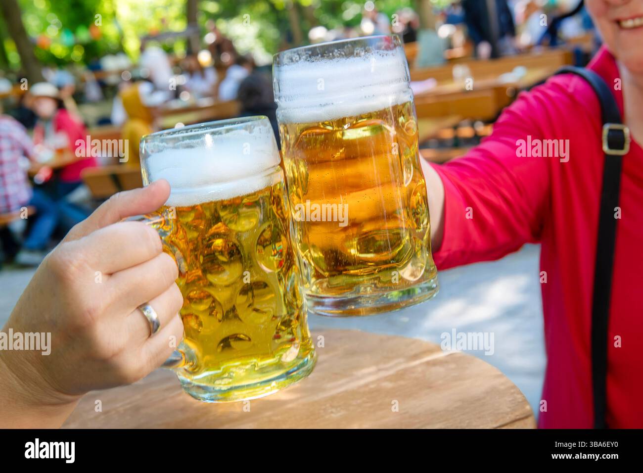 Zwei Münchnerinnen prosten sich in einem Biergarten zu, München, Mai ...