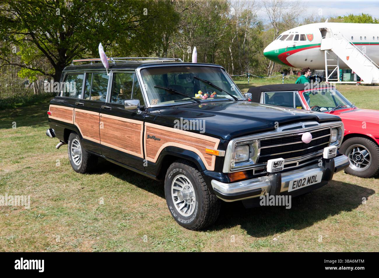 Three-quarters Front View of a Blue, 1988, Jeep Grand Wagoneer, in the aircraft park, at the ...