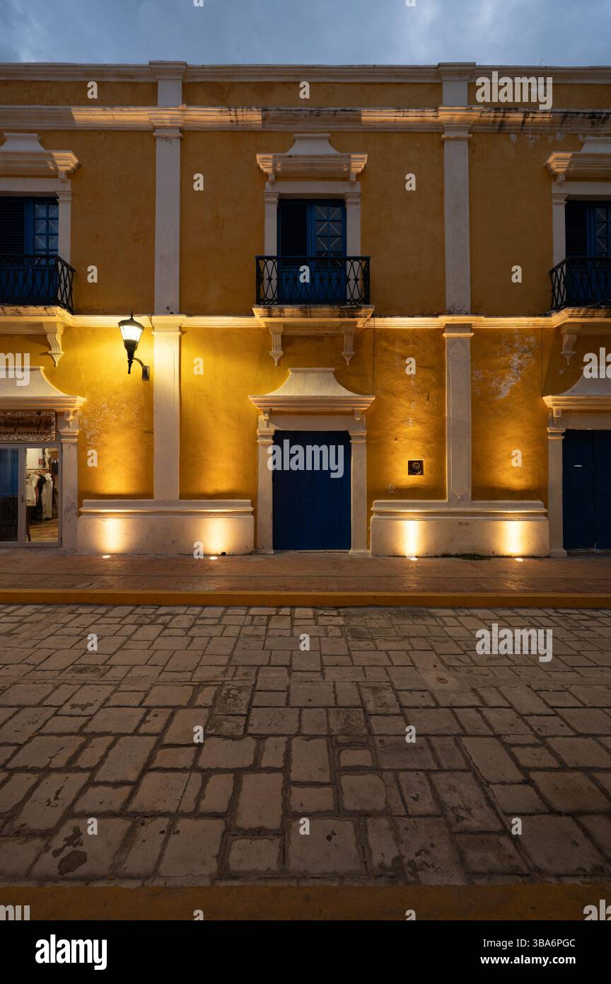 Yellow Spanish colonial building with blue doors at night in Campeche ...