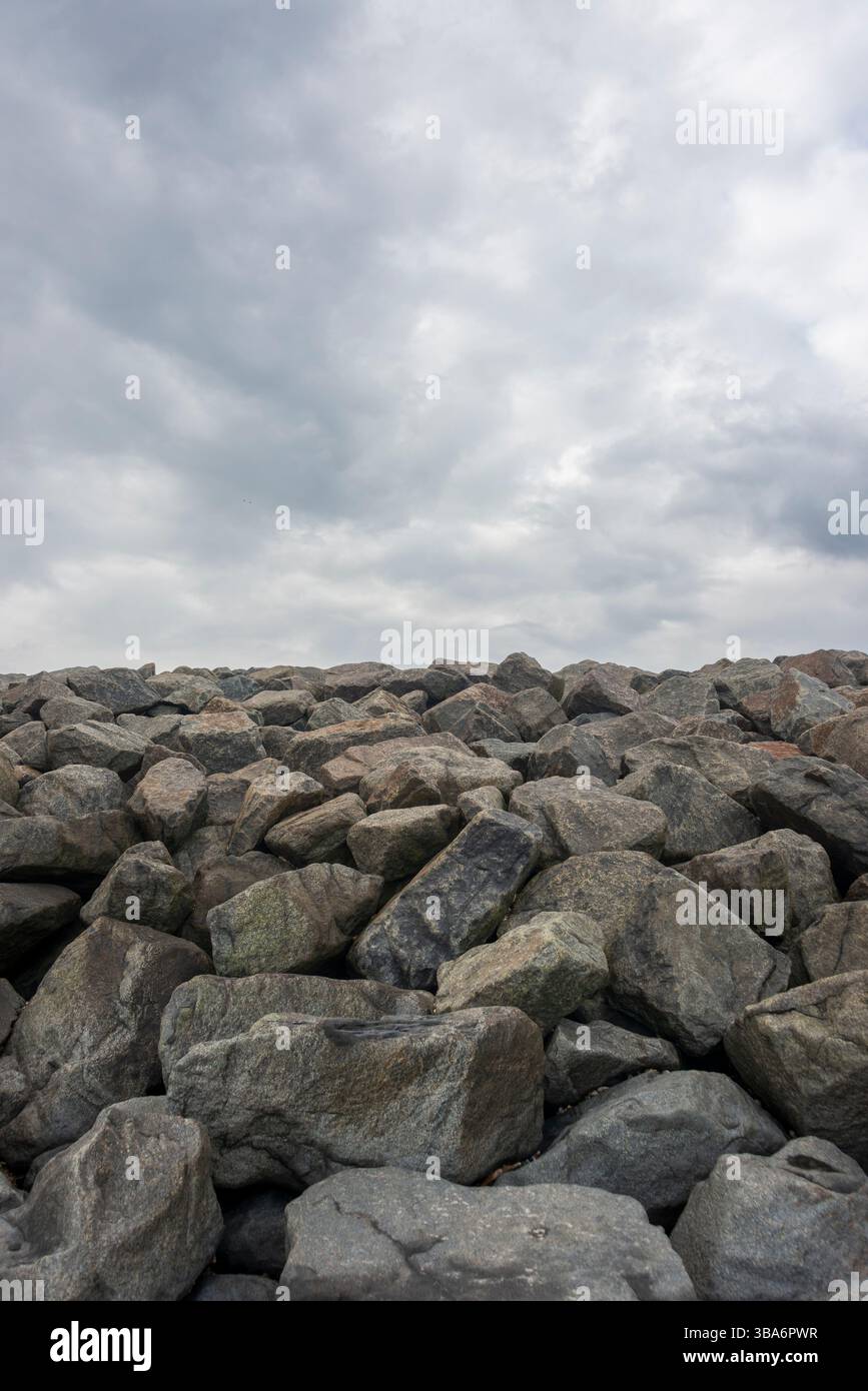 Rocks and boulders seawall defence with dramatic sky Stock Photo - Alamy